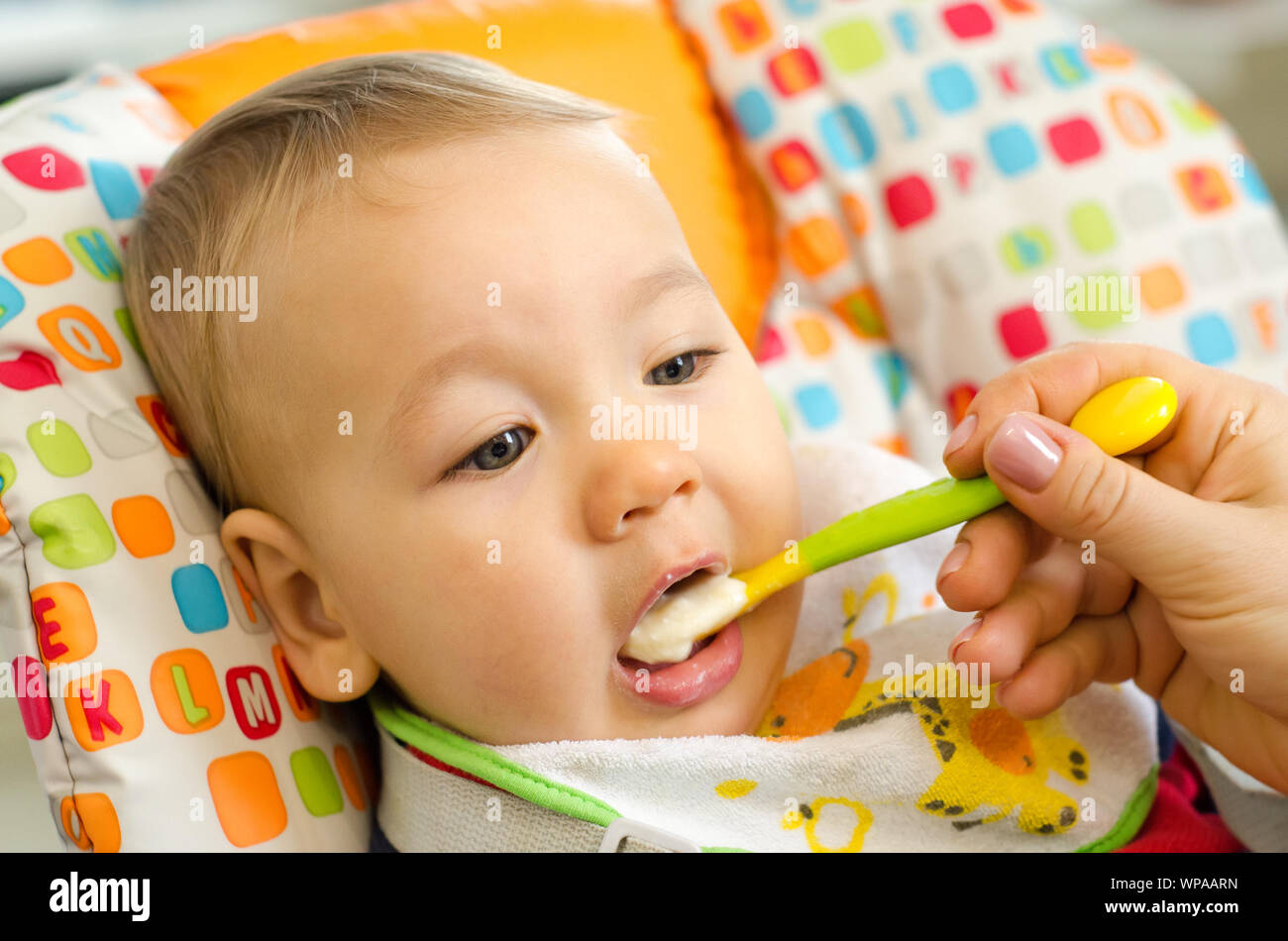 baby eating from a spoon Stock Photo - Alamy