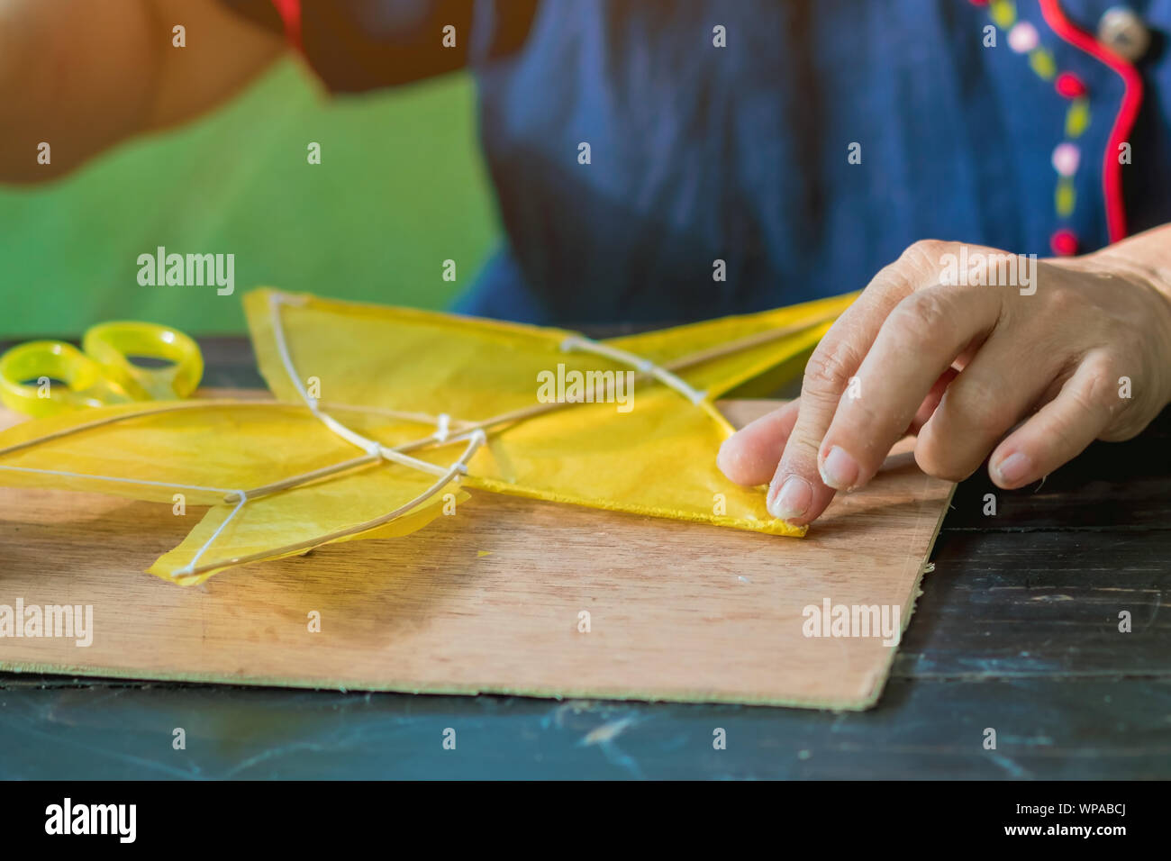 Eldery woman making and build star-shaped kite or thai name Chula kite ...