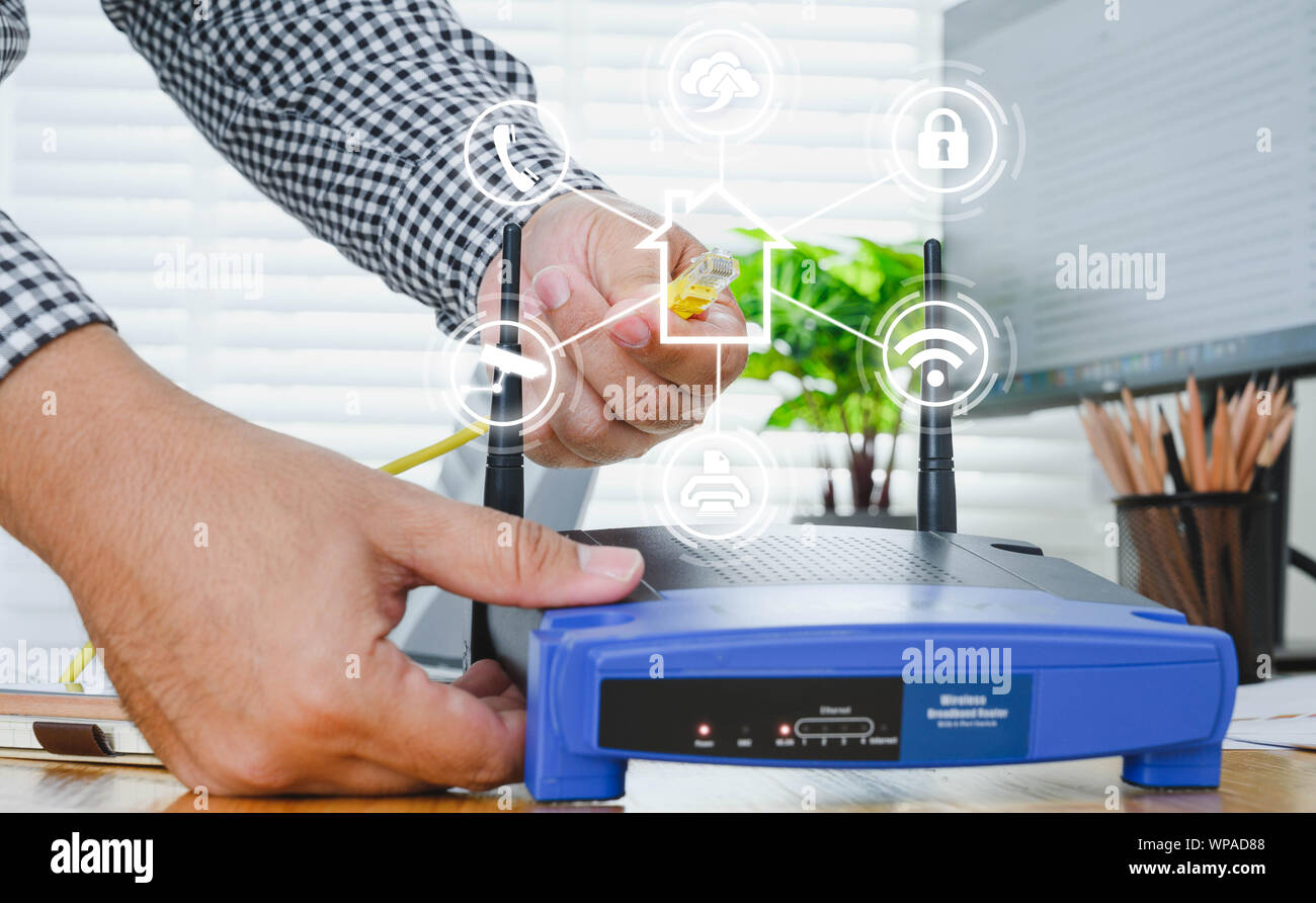 Man plugs internet cable into the router. router wireless wire ...