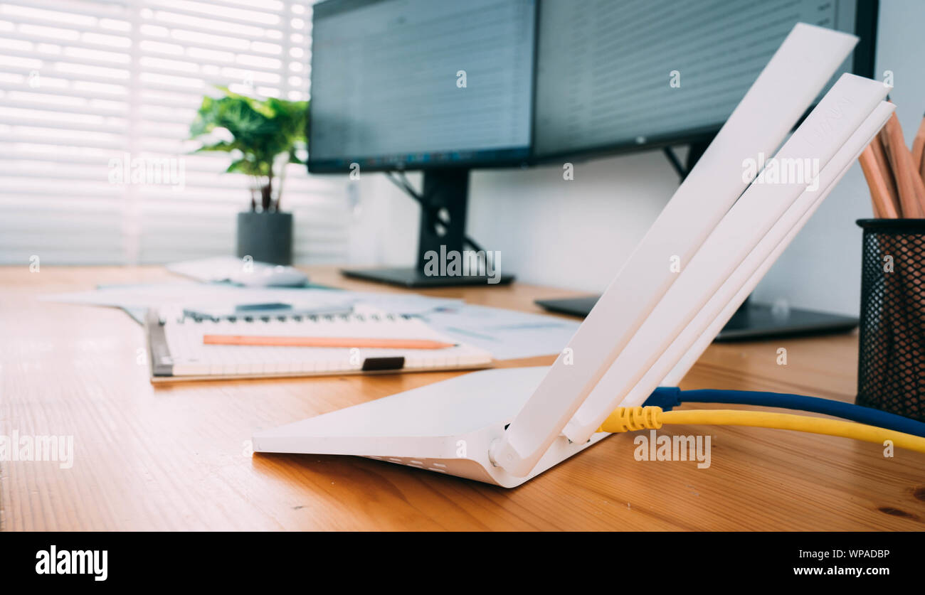 Modern Wi-Fi router on light table in home office Stock Photo - Alamy