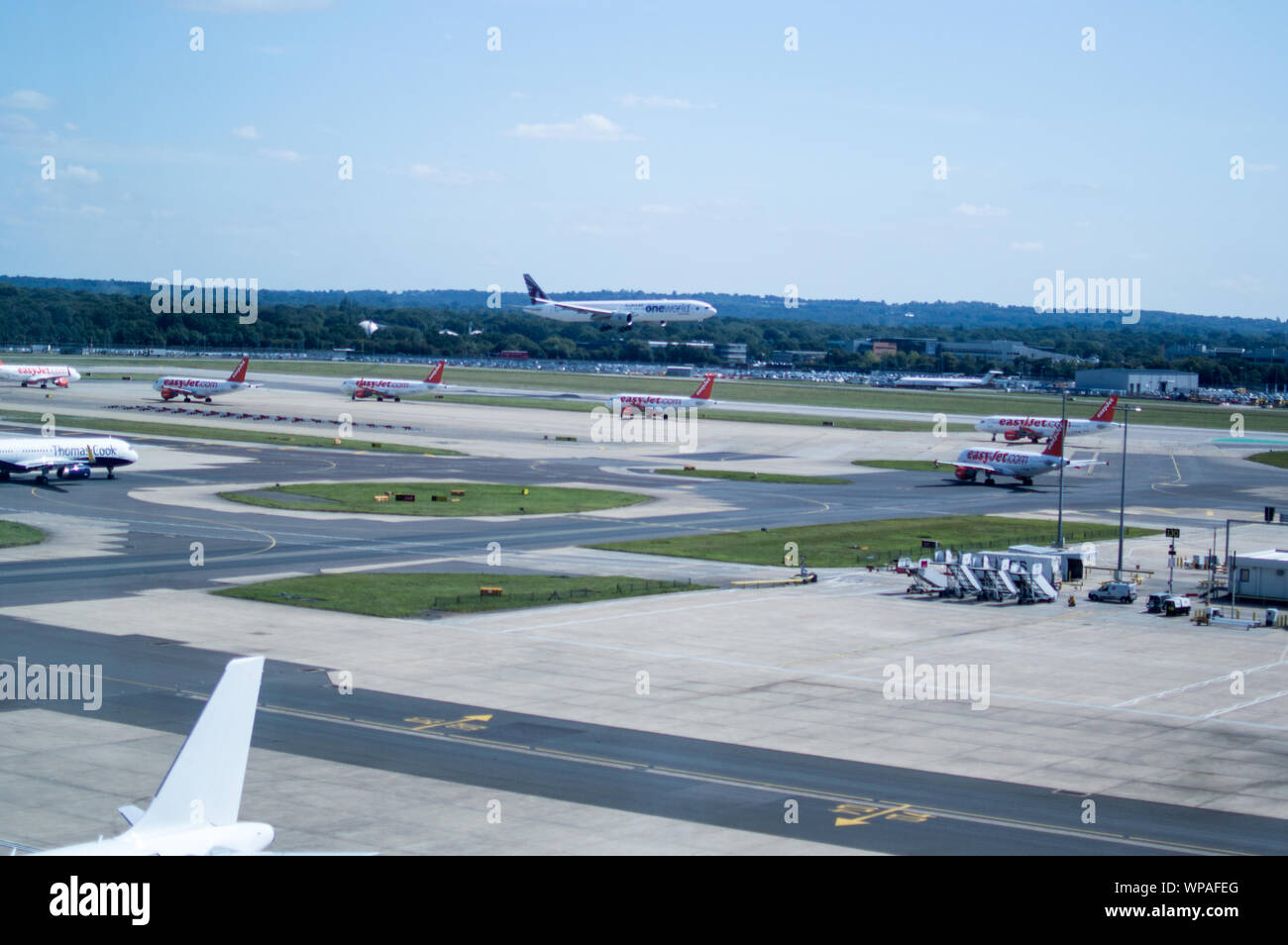 Airplanes lining up for take-off whilst a plane lands on runway Stock ...