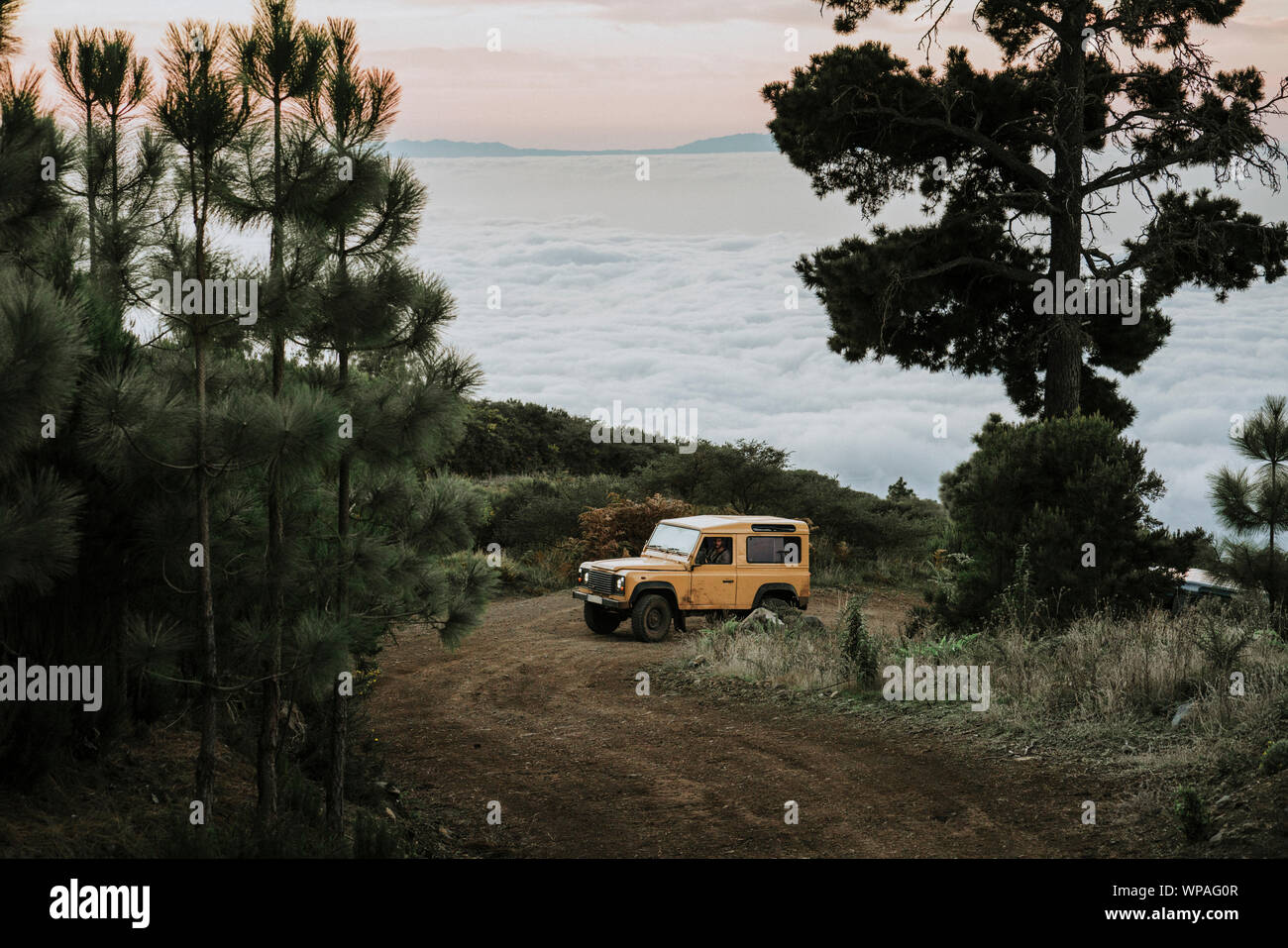 Man driving a 4x4 during sunset above the clouds Stock Photo - Alamy