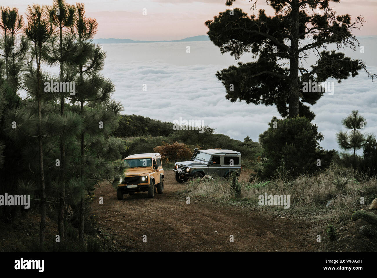 Friends driving two 4x4 during sunset above the clouds Stock Photo - Alamy