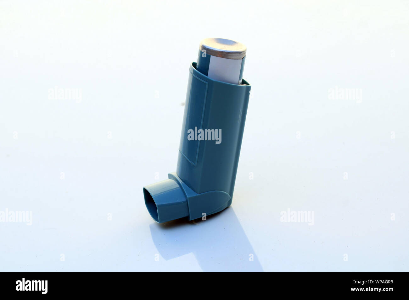 Medicine and health concept: Blue inhaler on a white background ...