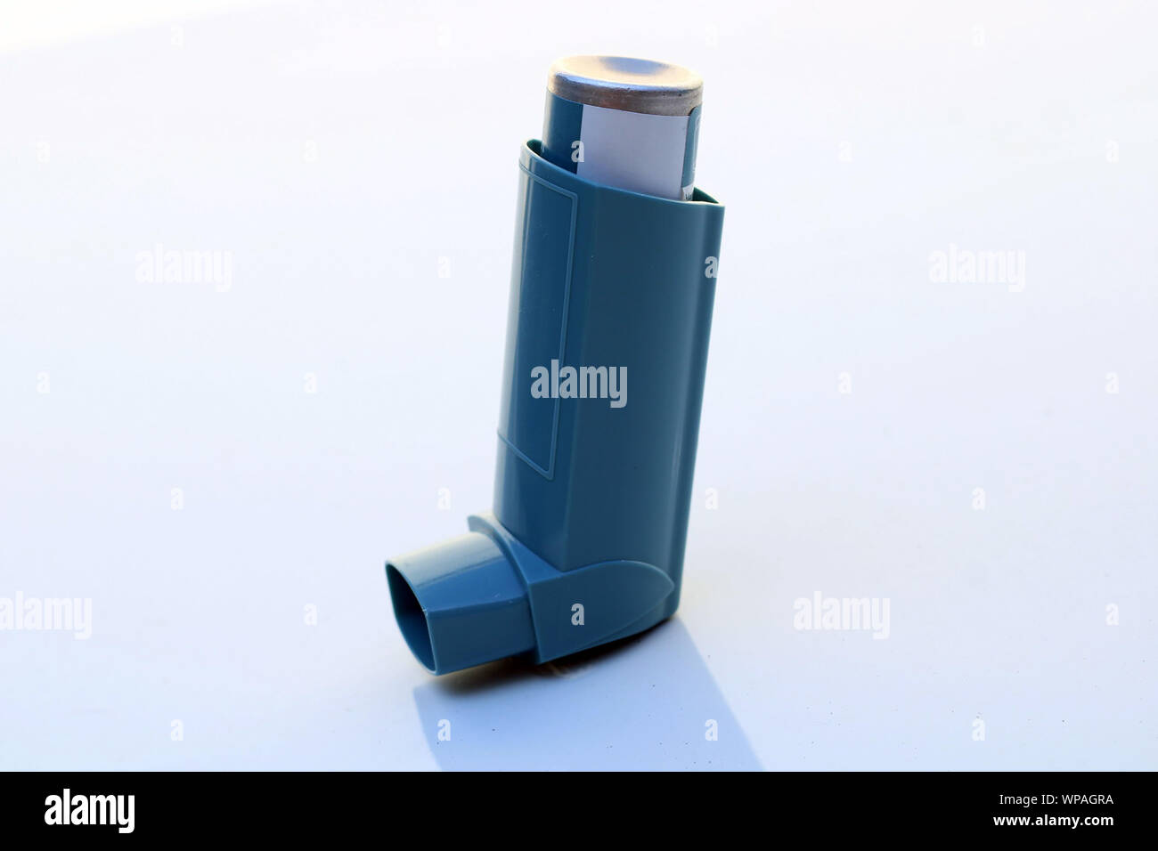 Medicine and health concept: Blue inhaler on a white background ...