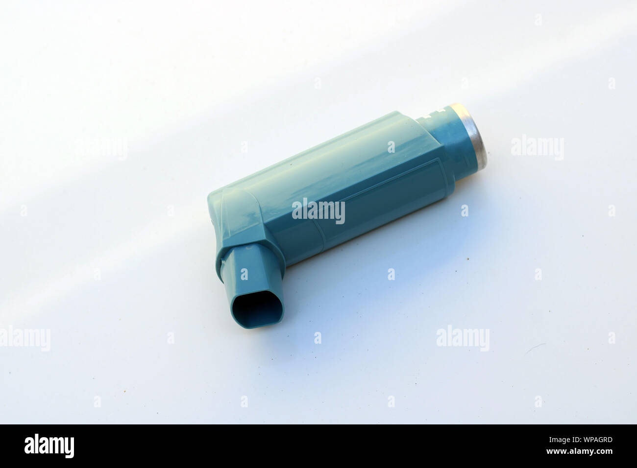 Medicine and health concept: Blue inhaler on a white background ...