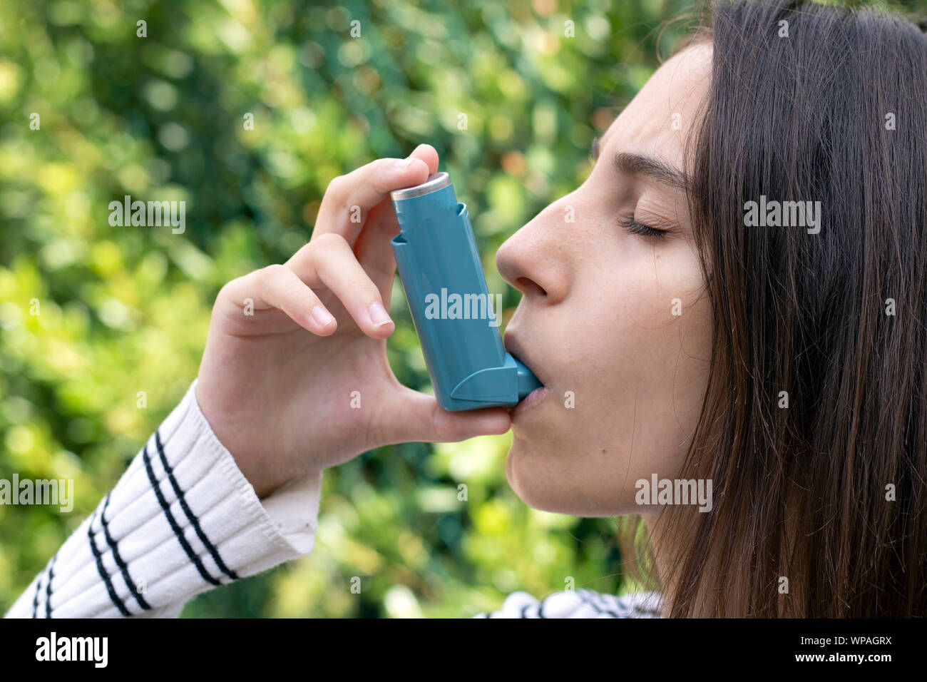 Health and medicine - Young girl using blue asthma inhaler to prevent ...