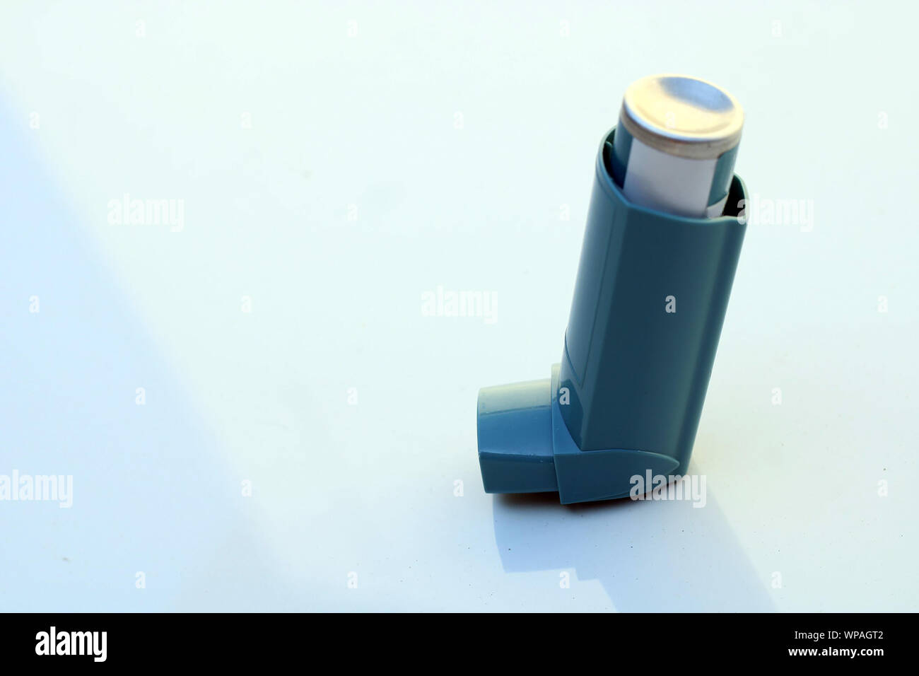 Medicine and health concept: Blue inhaler on a white background ...