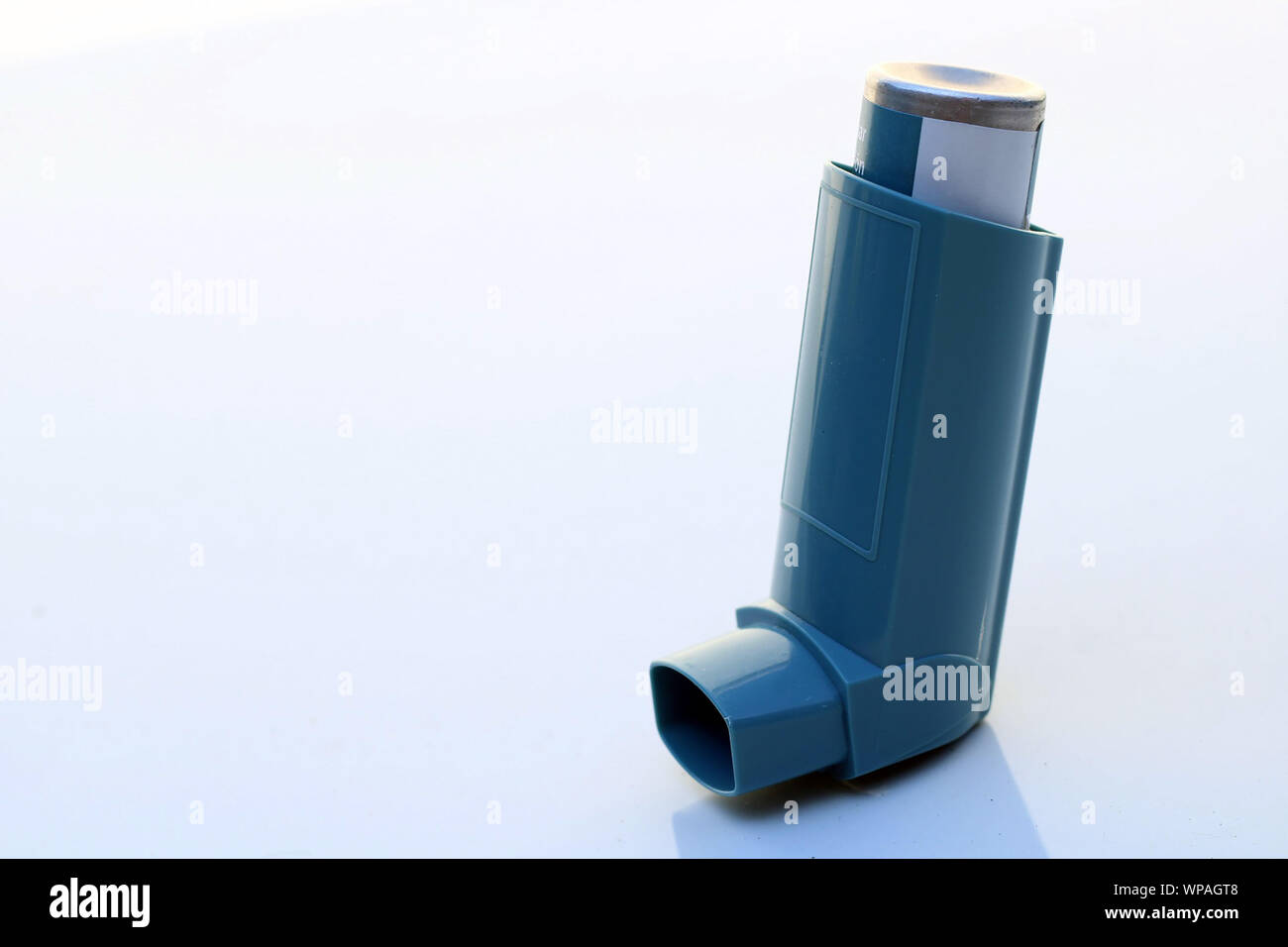 Medicine and health concept: Blue inhaler on a white background ...