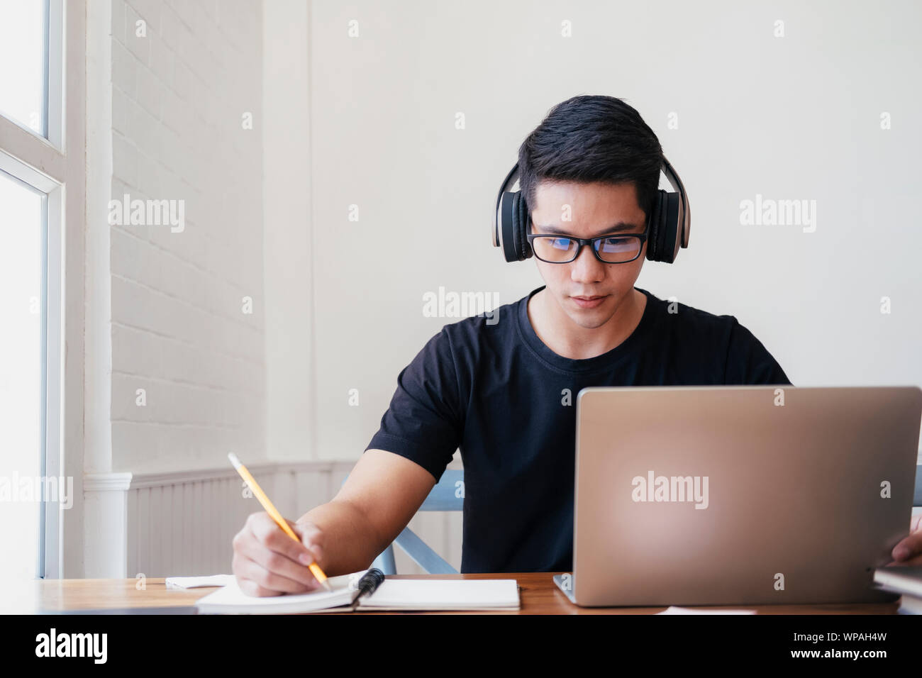 Young man student study at home. He using laptop and learning online ...