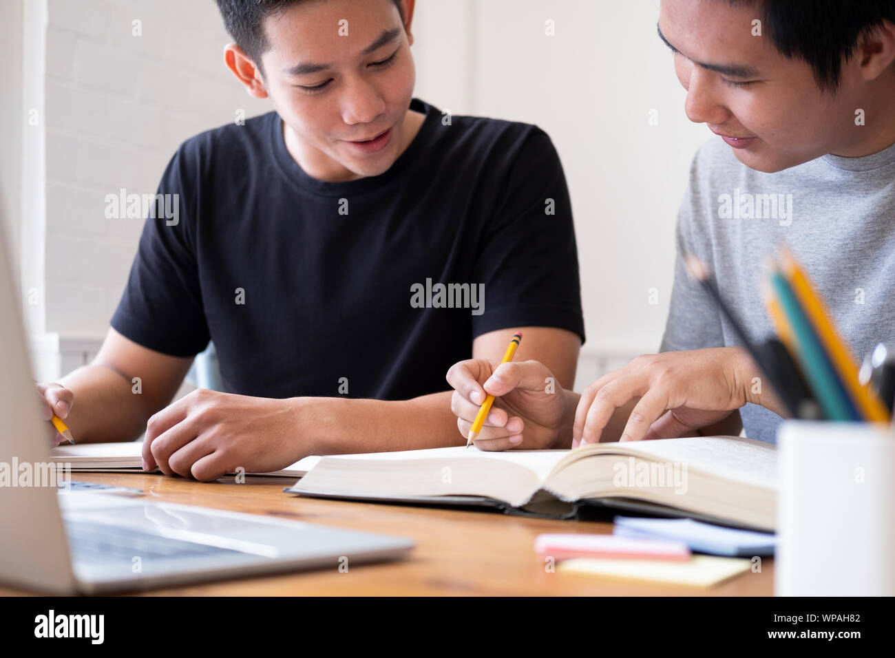 Learning, education and school concept. Young men studying for a test ...