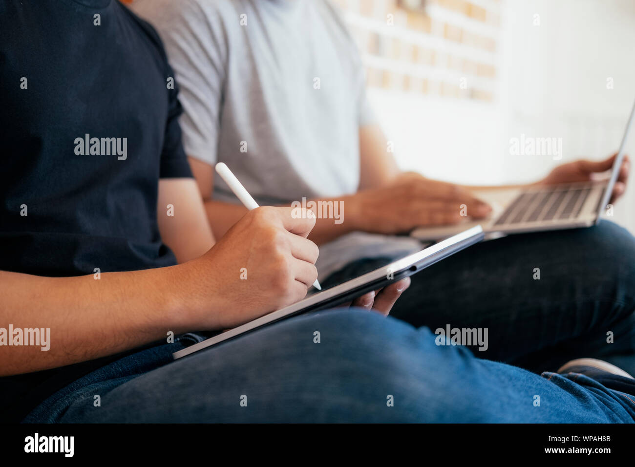 Young teenage men using computer and tablet for online learning Stock ...