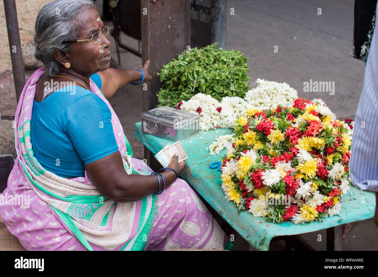 Indian women selling flowers outside the temple of Srirangam in the ...