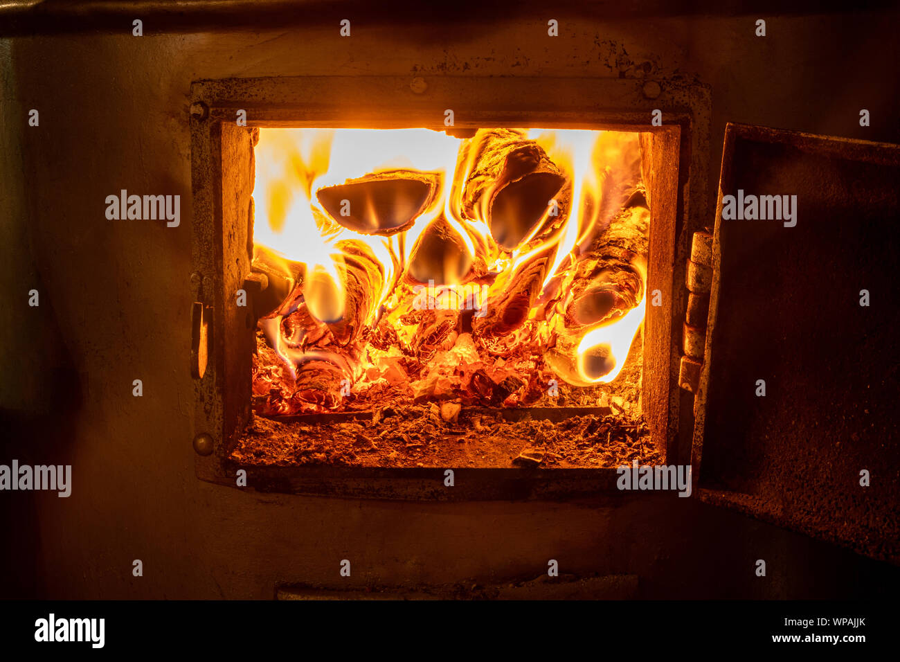 Metallic rural furnace with burning fire inside it and illuminated by ...