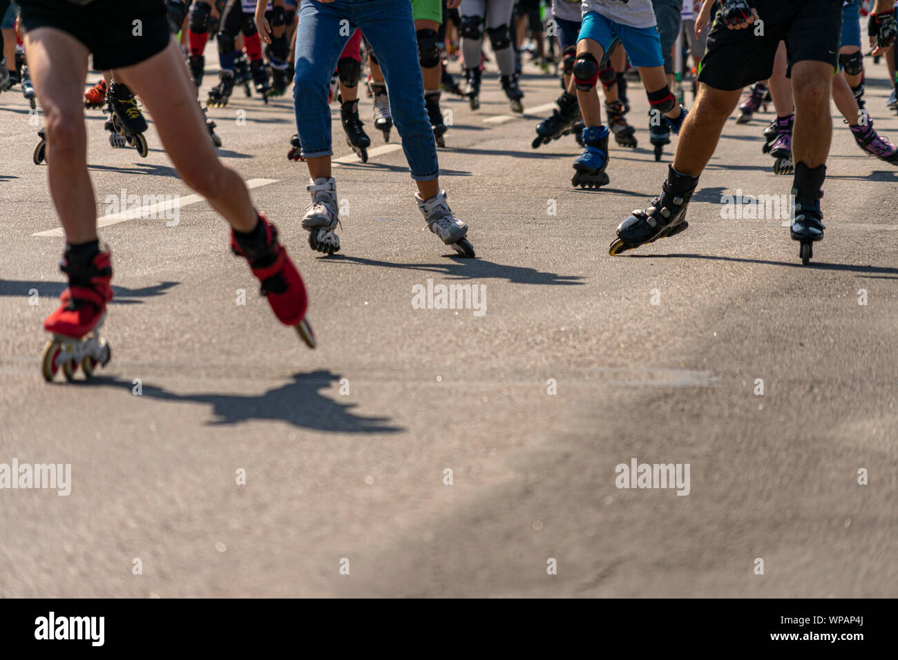 Many legs in roller-blades. People participate in outdoors racing ...