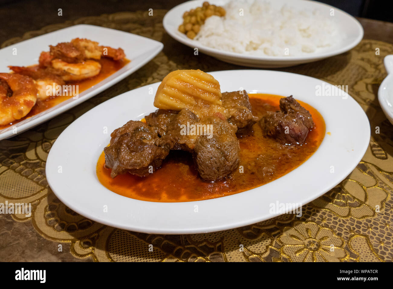 Burmese Myanmar lamb curry in plate, shrimp and dip in background Stock ...