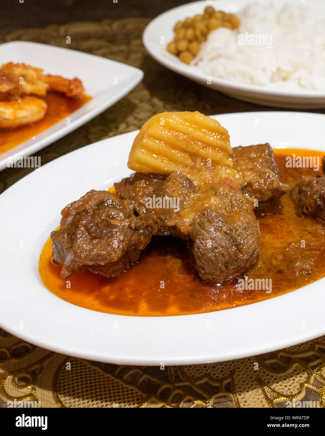 Burmese Myanmar lamb curry in plate, shrimp and dip in background Stock ...