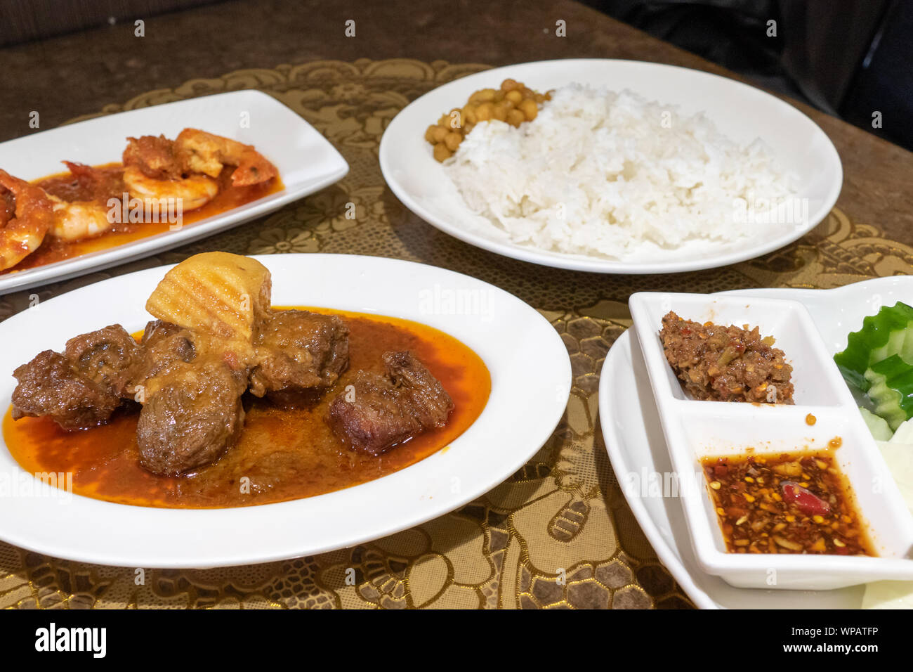 Burmese Myanmar lamb curry in plate, shrimp and dip in background Stock ...