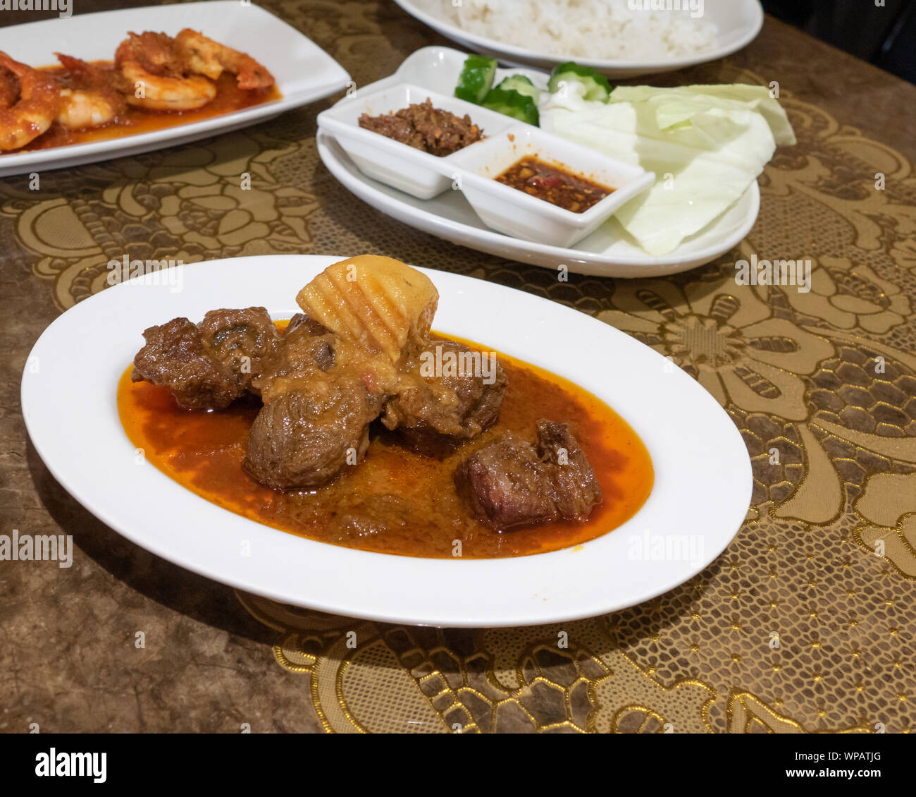 Burmese Myanmar lamb curry in plate, shrimp and dip in background Stock ...