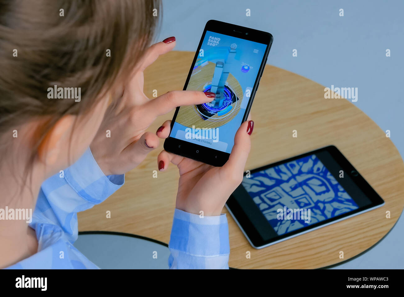 Woman using smartphone with augmented reality app and placing model of ...