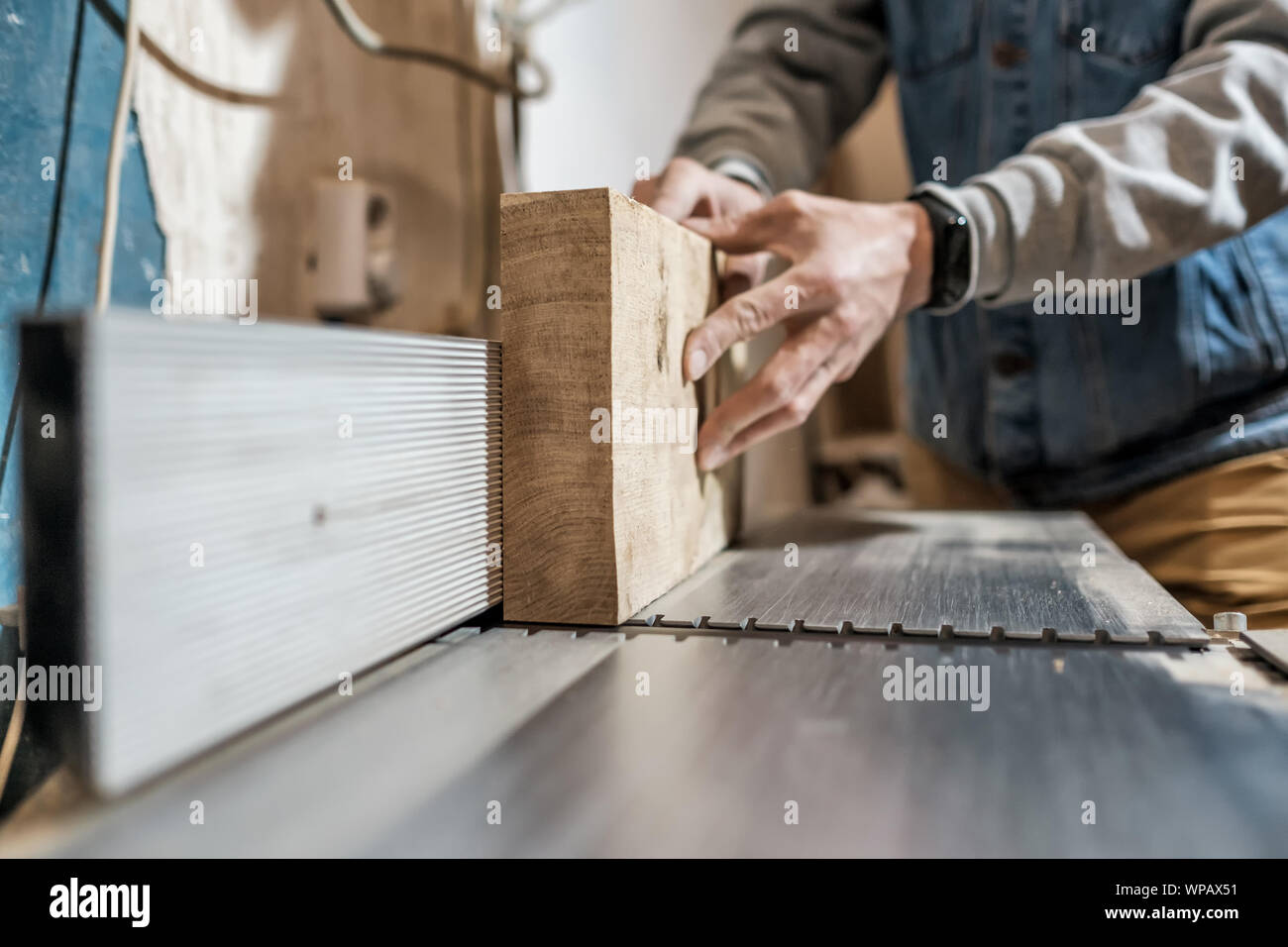 Caucasian man making wooden parts for custom furniture on machine tool ...