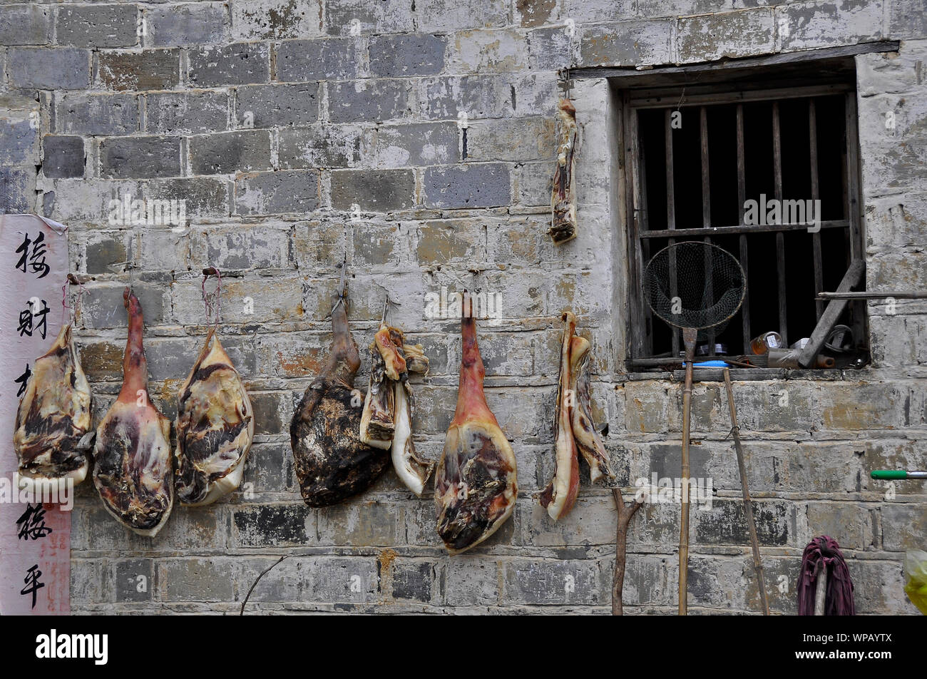 Curing ham hangs from a farmhouse wall in Yangzhou, China Stock Photo ...