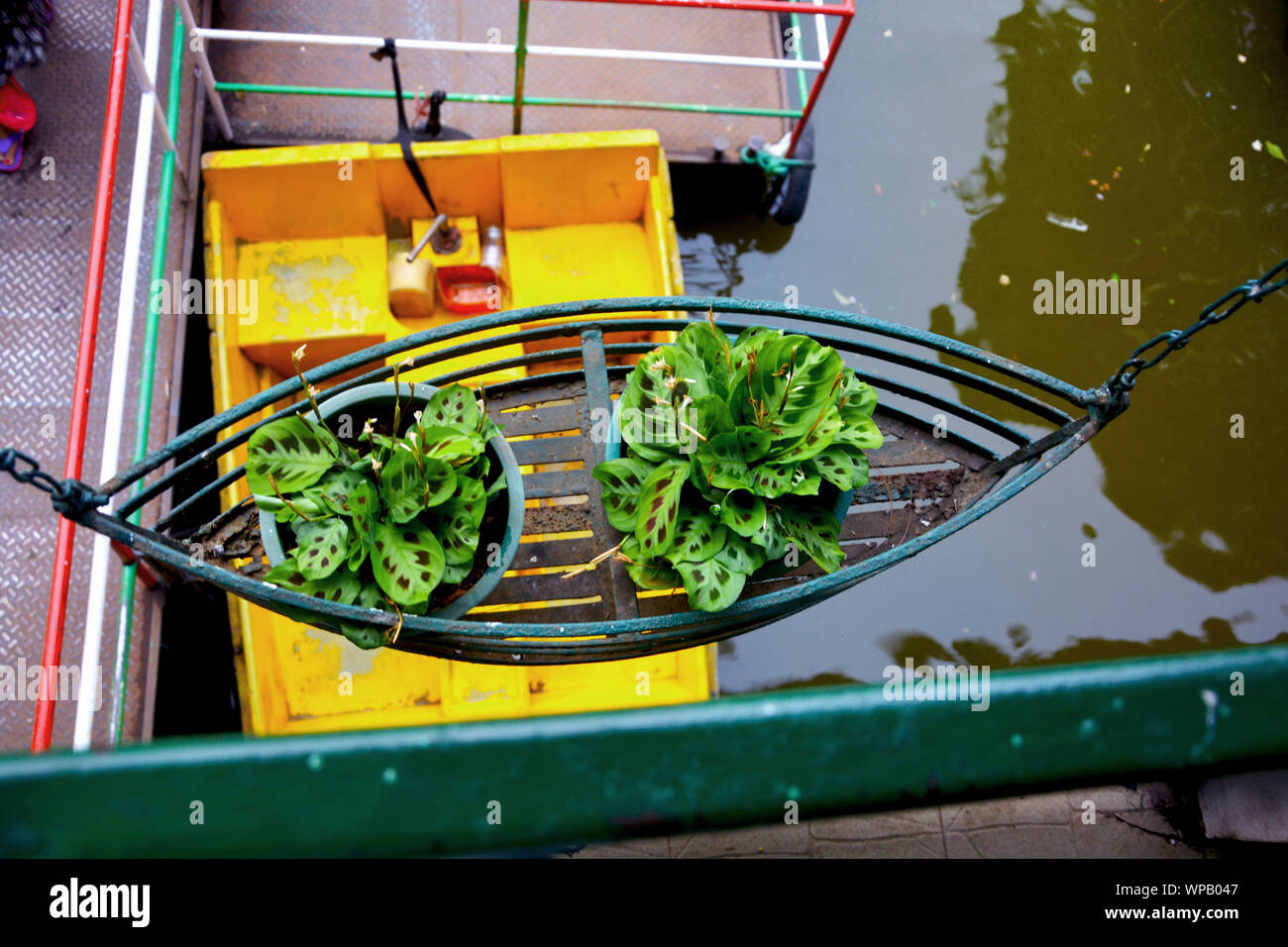Two pot hanging from a small boat made from iron rod containing two ...