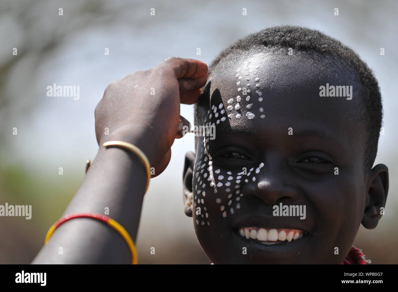 Painting face of a Karo girl Stock Photo - Alamy