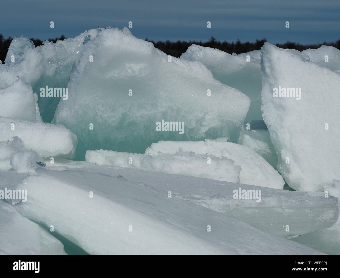 Thick slabs of frozen ice broken and piled on shore of the Ottawa River ...