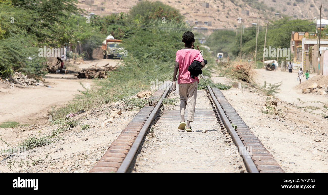 Child walking down railroad track in the desert of Ethiopia near ...