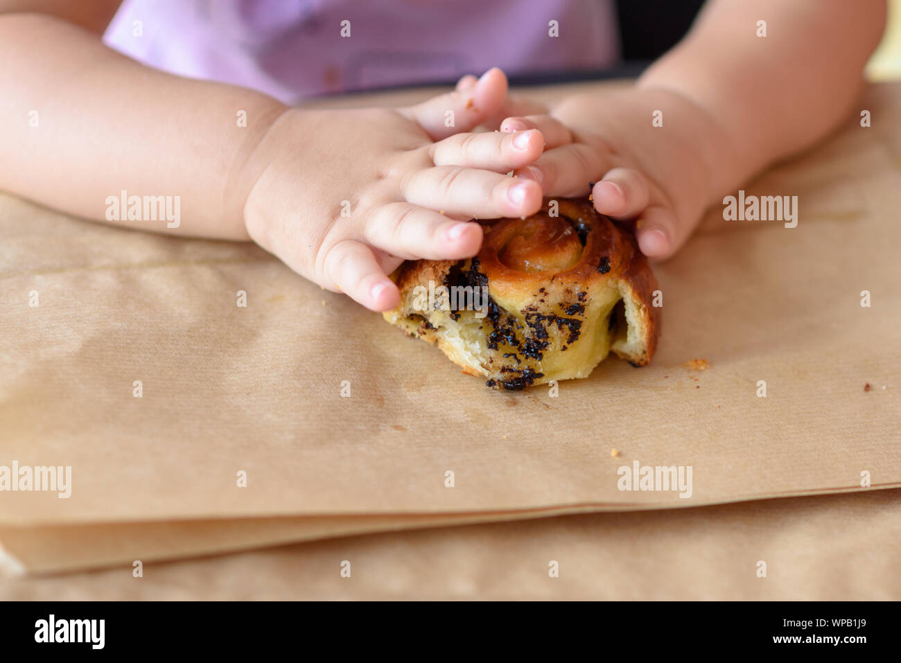 Breakfast in restaurant on eco paper bag. Kid eat croissant or bun roll ...