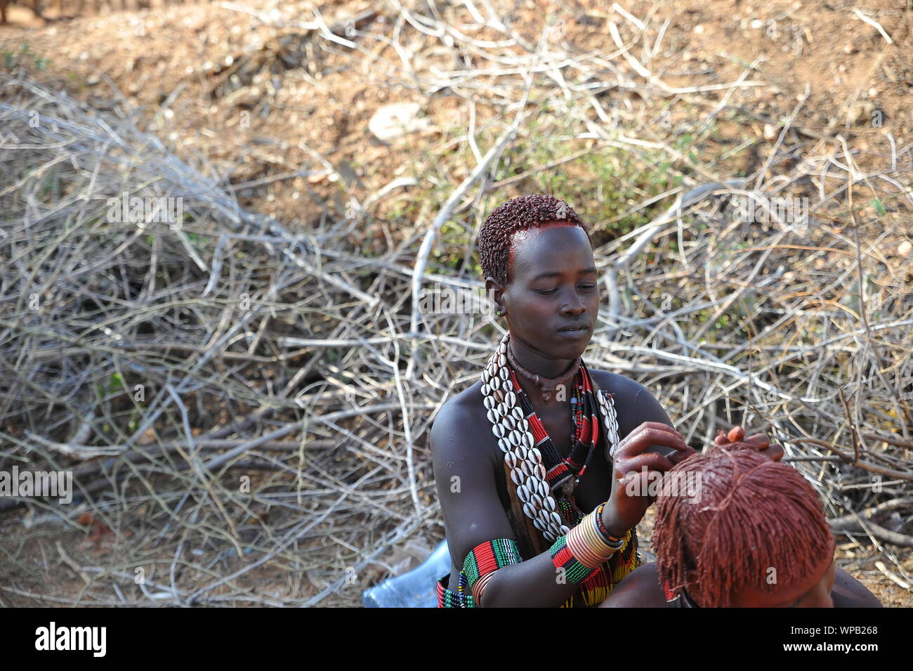 Making the typical red hair red of the Hamer tribe in the south of ...