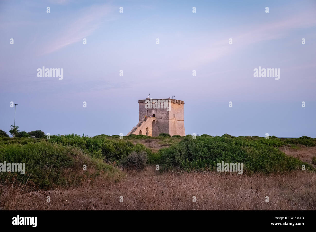 View of the ancient defensive coastal tower Torre Lapillo at the sunset ...