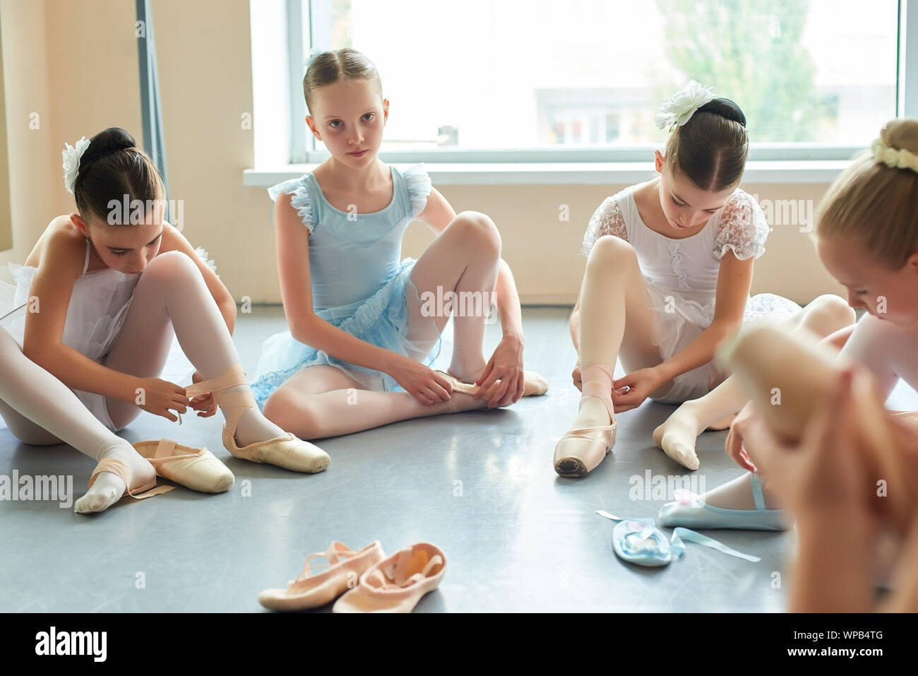 Young ballerina sitting on floor and looking at camera Stock Photo - Alamy