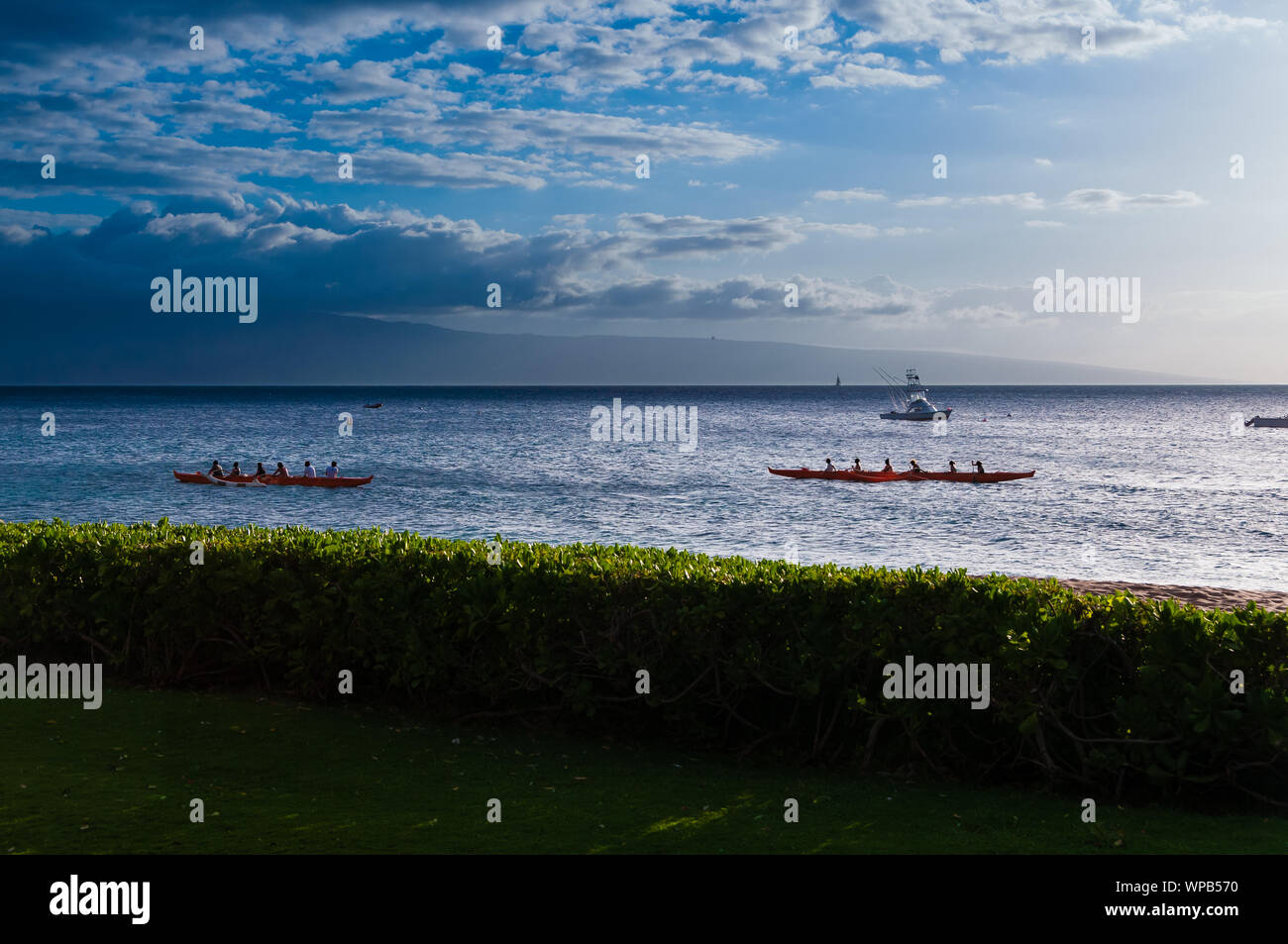 Two native Hawaiian boats rowing past at sunset on Maui, Hawaii, USA ...
