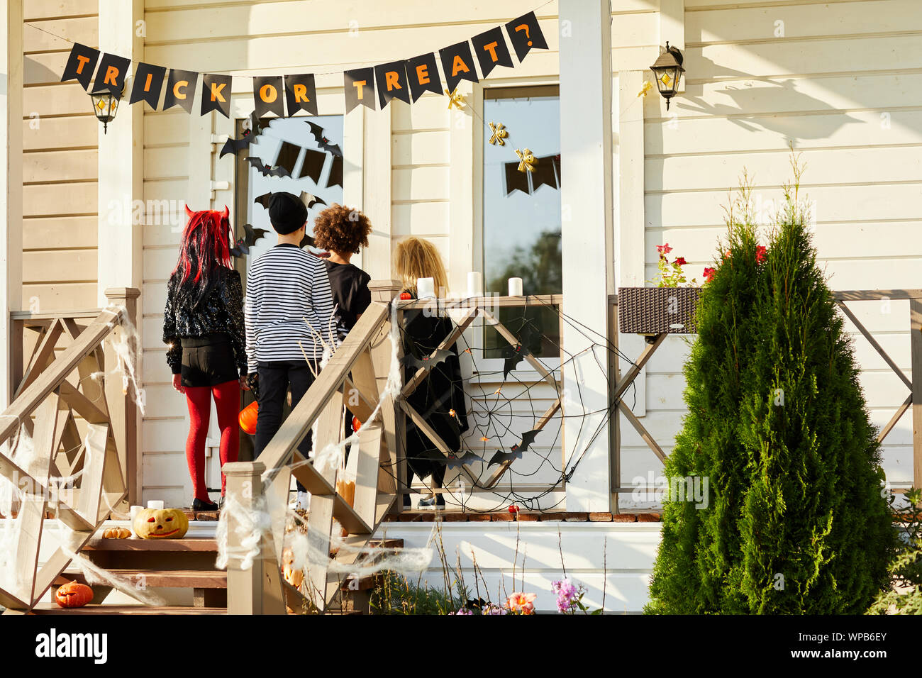 Back view of children trick or treating on Halloween, kids standing on ...