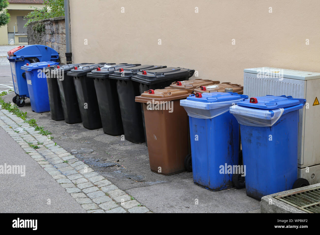 Various garbage cans stand on the street Stock Photo - Alamy