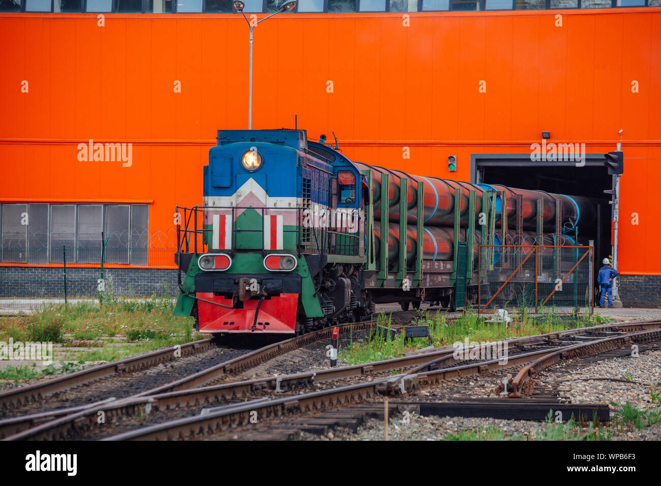 Freight train with new manufactured pipes exits from warehouse Stock ...