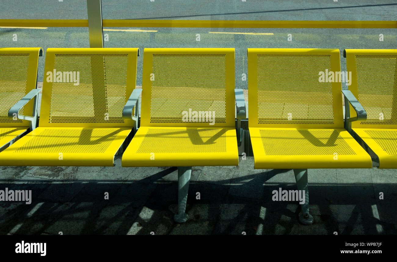 A line of yellow seats at a bus stop in the UK Stock Photo - Alamy