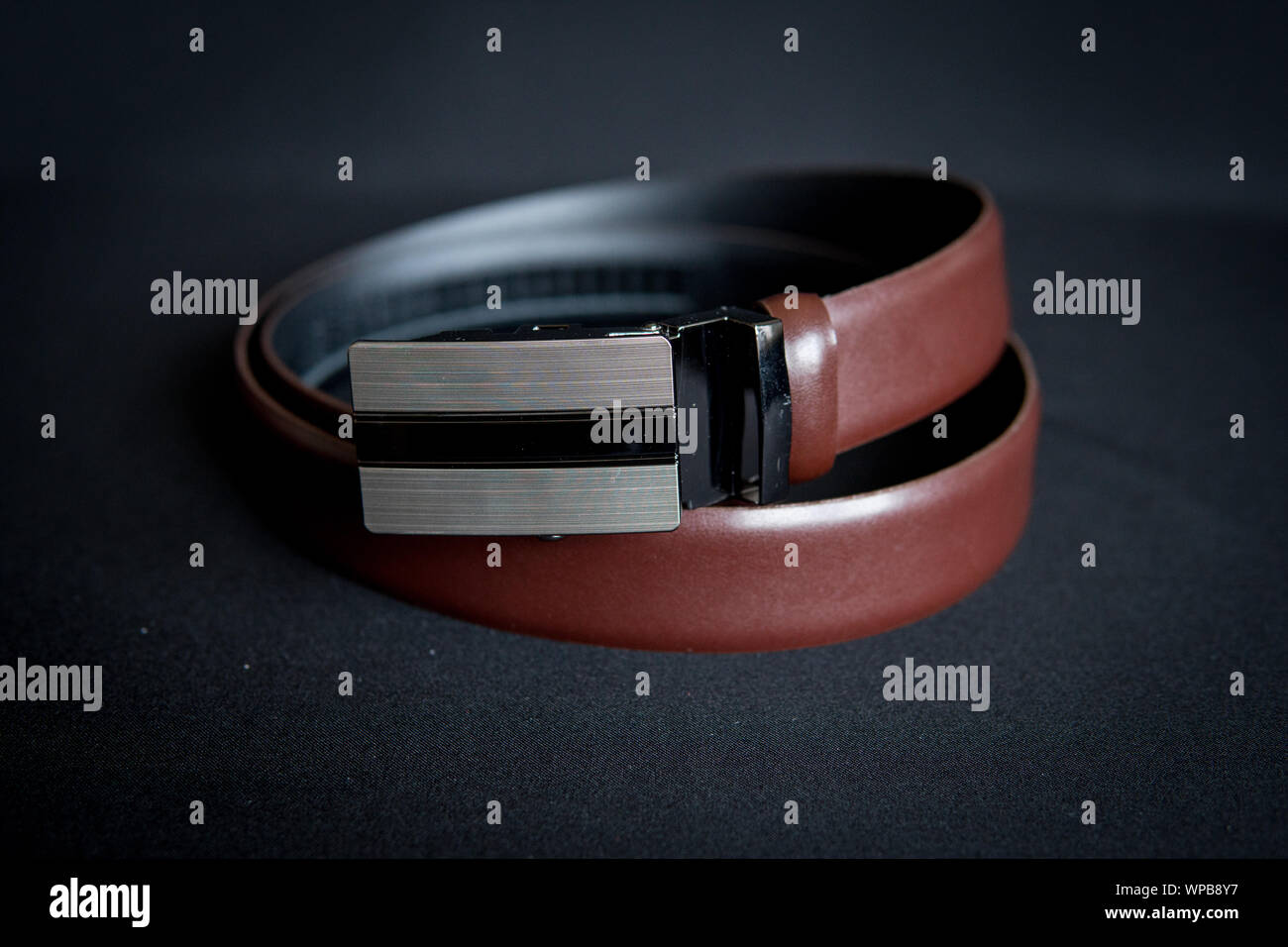 detail of a men's brown belt isolated over black background Stock Photo ...