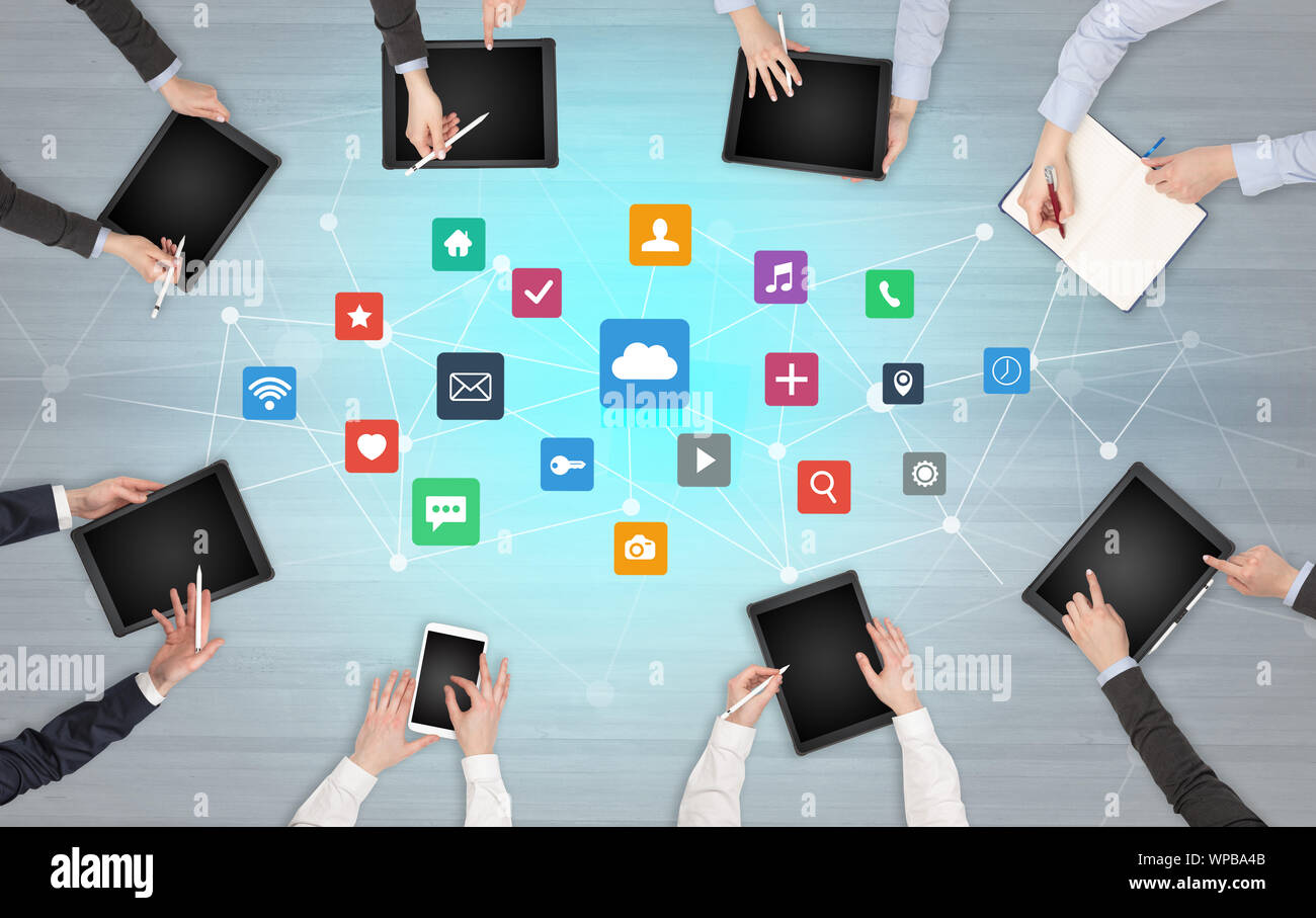 Group of people with devices in hands working in team on tablets ...