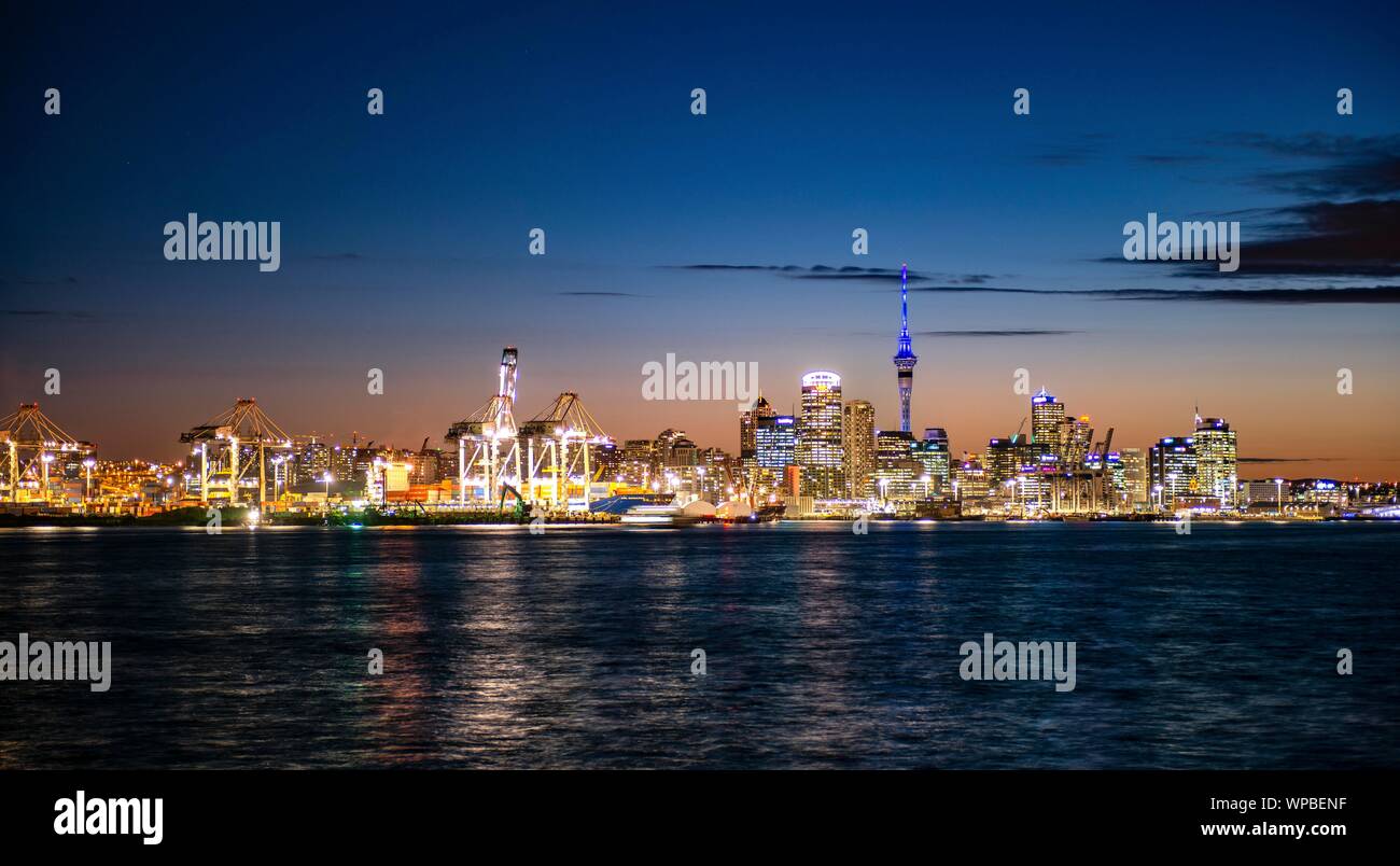 Illuminated skyline of Auckland at sunset, Waitemata Harbour, Sky Tower ...
