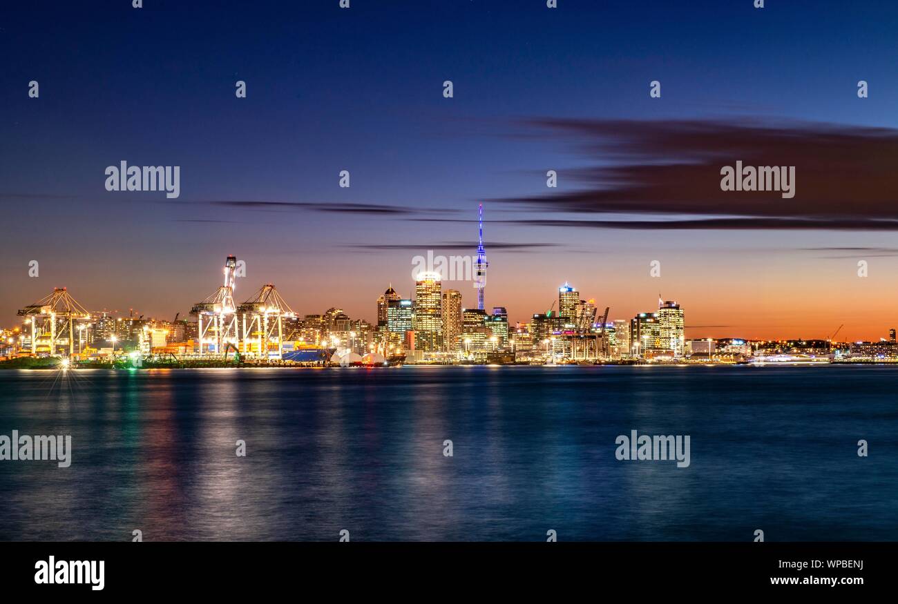 Illuminated skyline of Auckland at sunset, Waitemata Harbour, Sky Tower ...