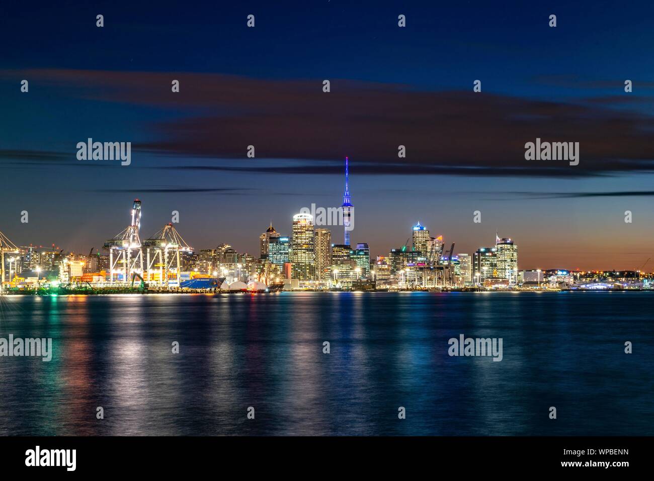 Illuminated skyline of Auckland at sunset, Waitemata Harbour, Sky Tower ...