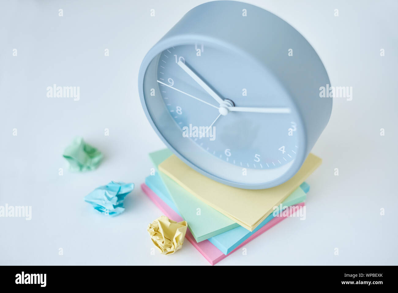 Gray round alarm clock and colorful sticky notes on white background ...
