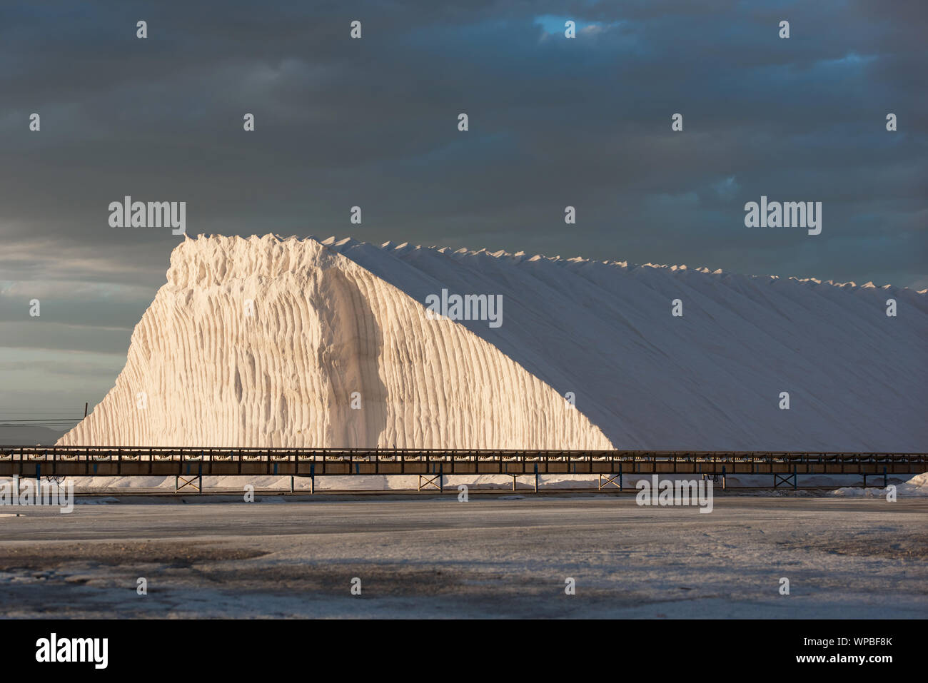 mountain of fresh produced sea salt in open surface saline with flat ...