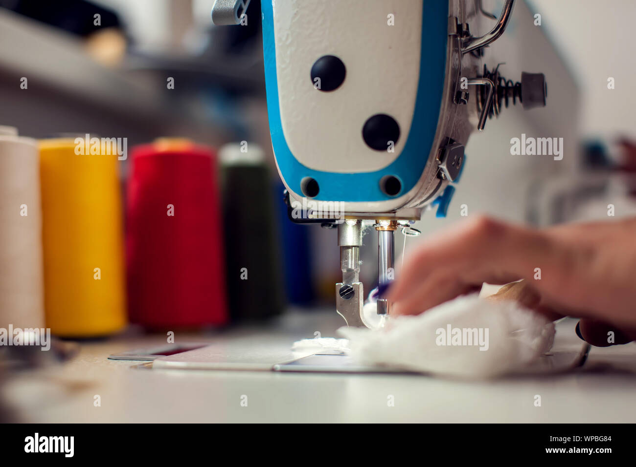 A tailor works with sewing machine. Manufacture of wearing concept ...
