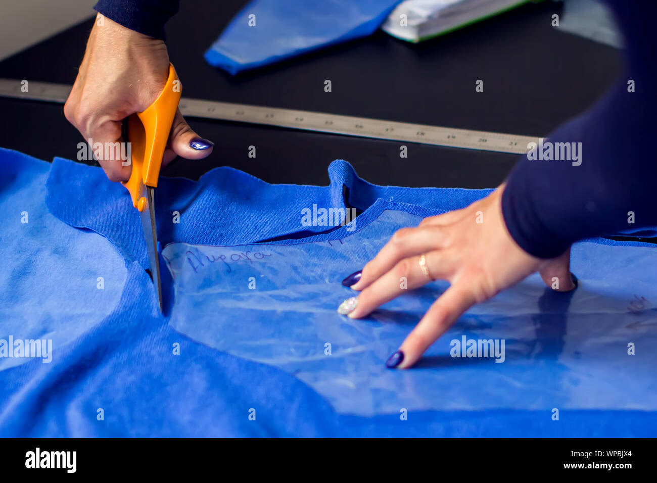 A tailor cuts textile. Manufacture of wearing and fashion concept Stock ...