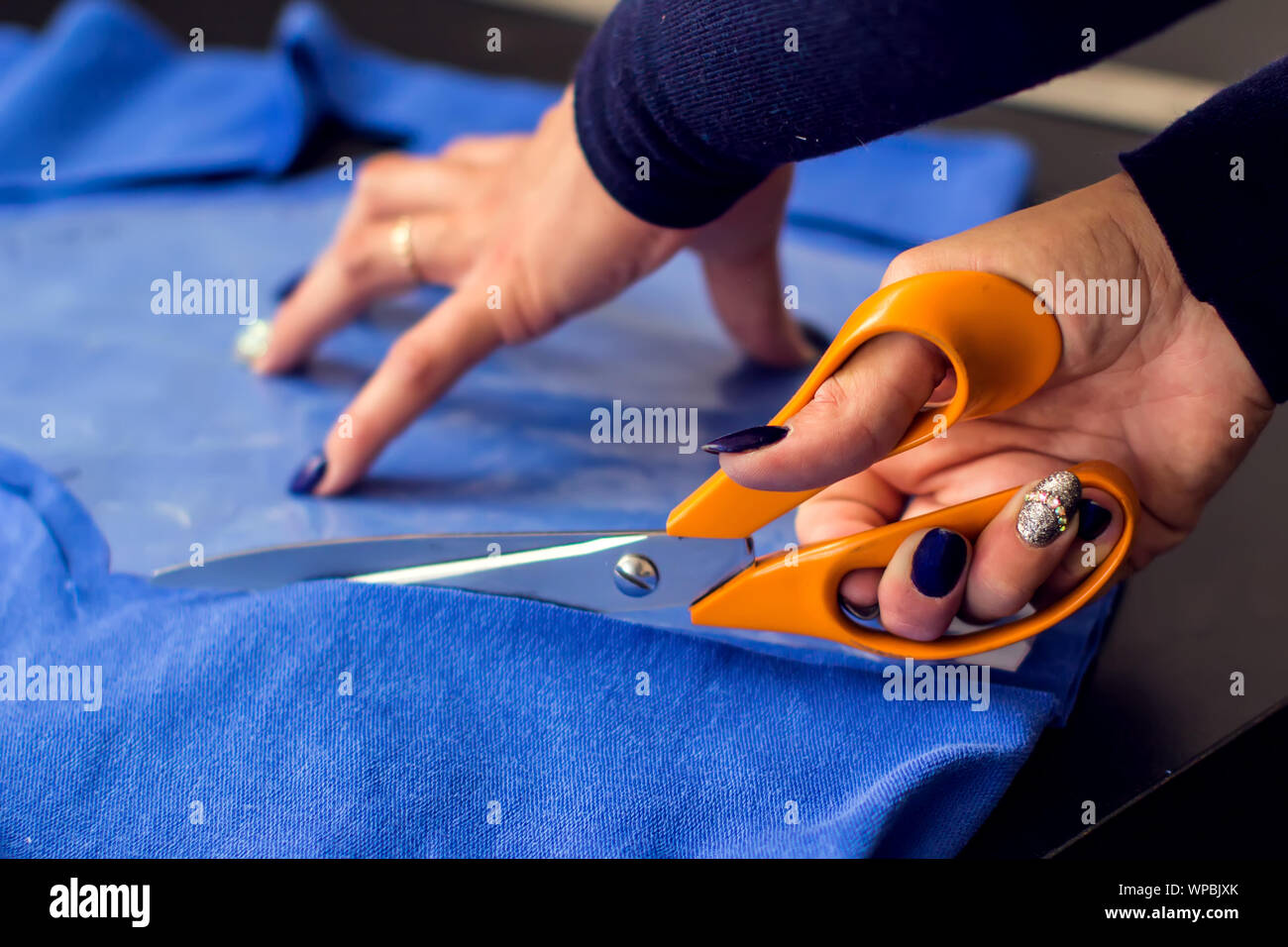 A tailor cuts textile. Manufacture of wearing and fashion concept Stock ...