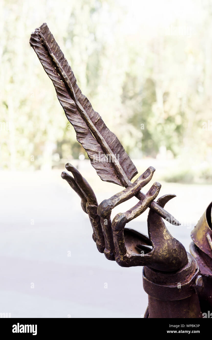 Hand with a pen for writing. Part of a metal statue Stock Photo - Alamy